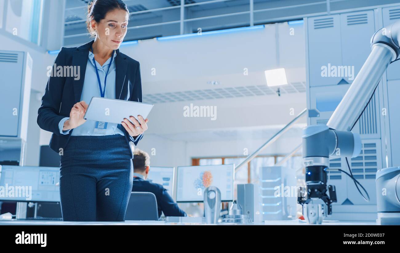 Stylish Female Industrial Robotics Engineer Uses Tablet Computer to ...
