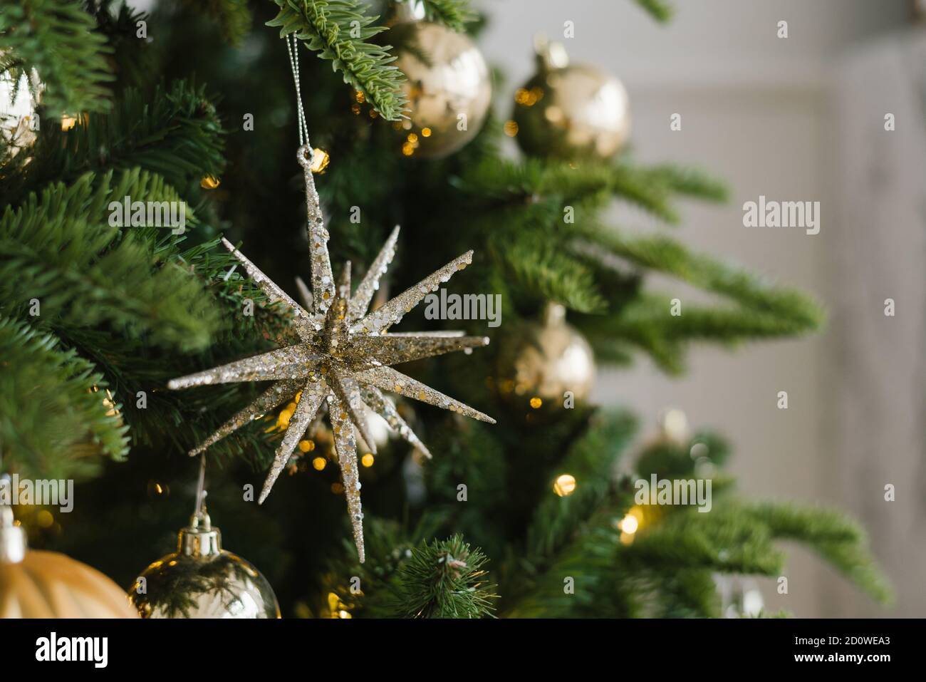 Christmas toy star and balls hang on the tree, decorated with lights ...