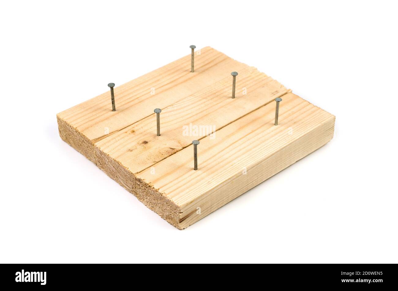 Demonstration of metal nails driven into wooden boards on a white ...