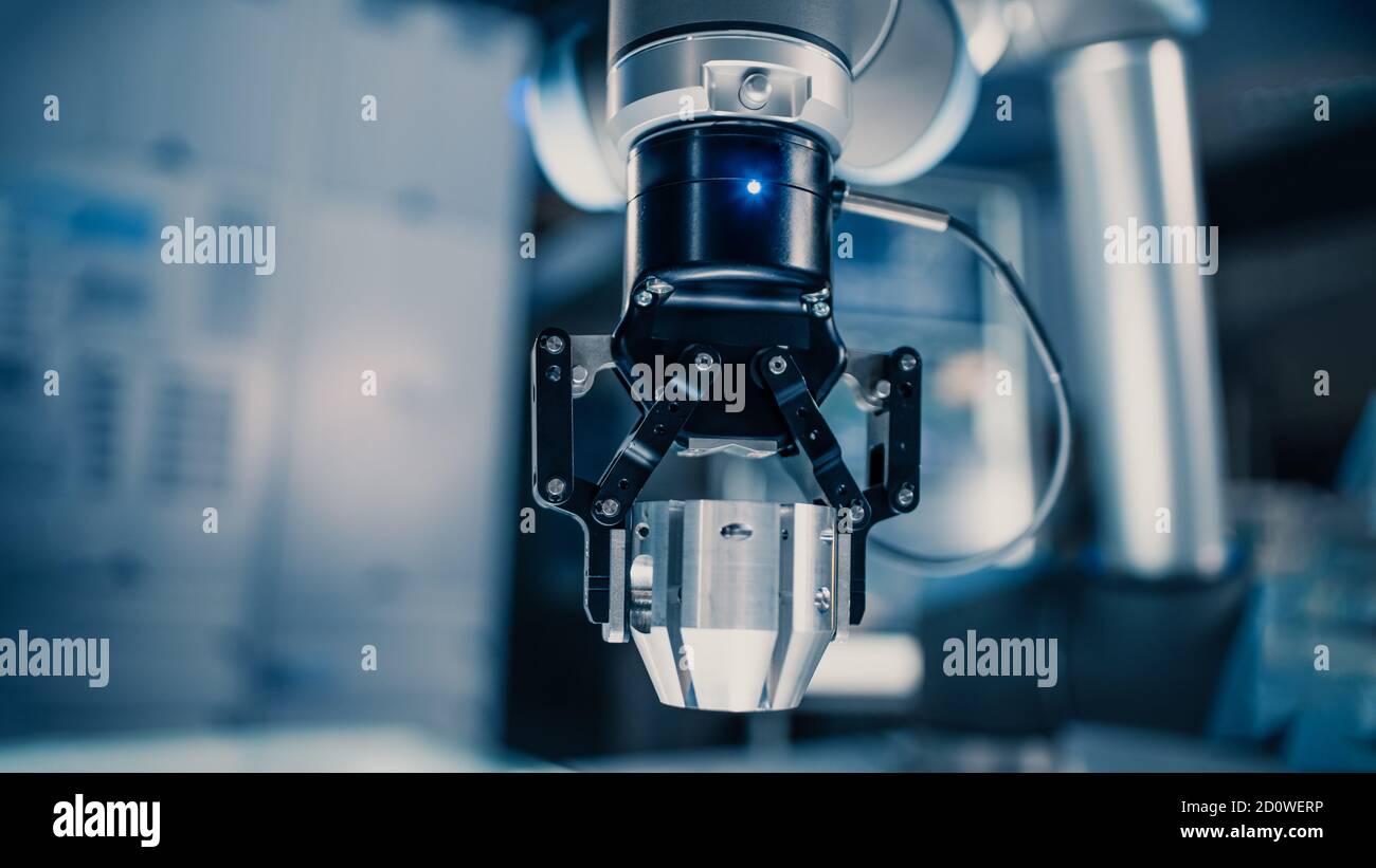 Close Up of a Futuristic Robotic Arm Moving a Metal Object and Placing ...