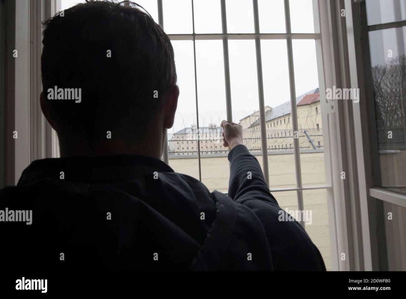 prisoner looking out of the window of a prison cell Stock Photo - Alamy