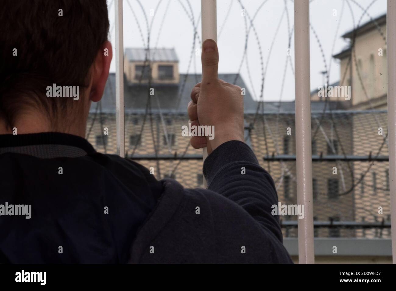 prisoner looking out of the window of a prison cell Stock Photo - Alamy