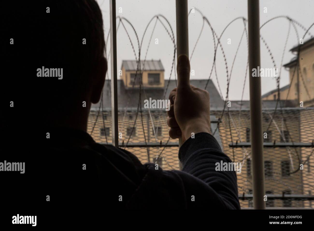 prisoner looking out of the window of a prison cell Stock Photo - Alamy