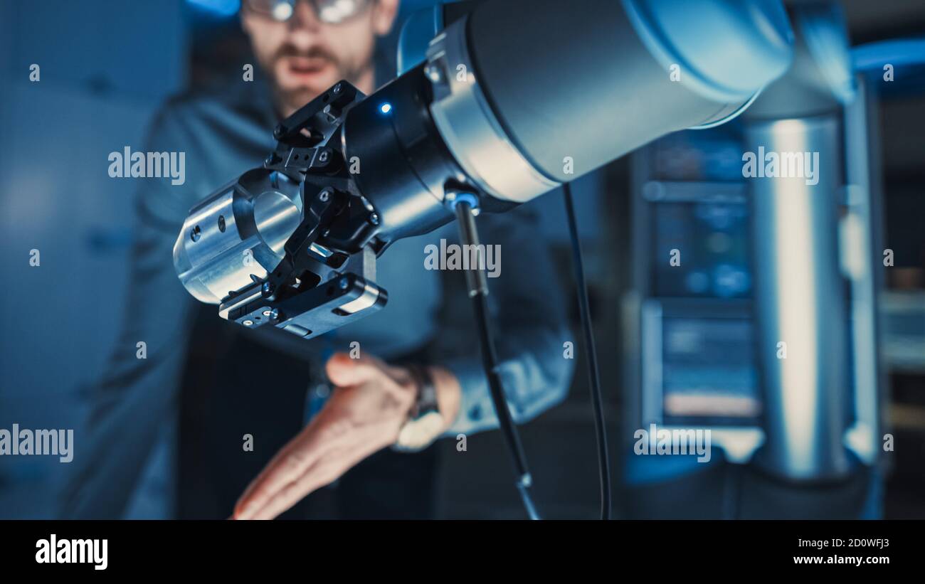 Close Up of a Futuristic Robotic Arm Moving a Metal Detail. Team of ...