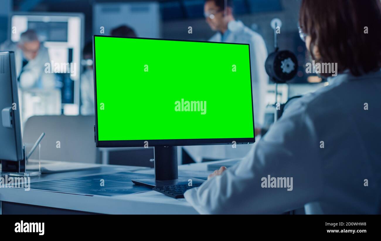 Over the Shoulder Shot: Female IT Scientist Uses Green Mock-up Screen ...