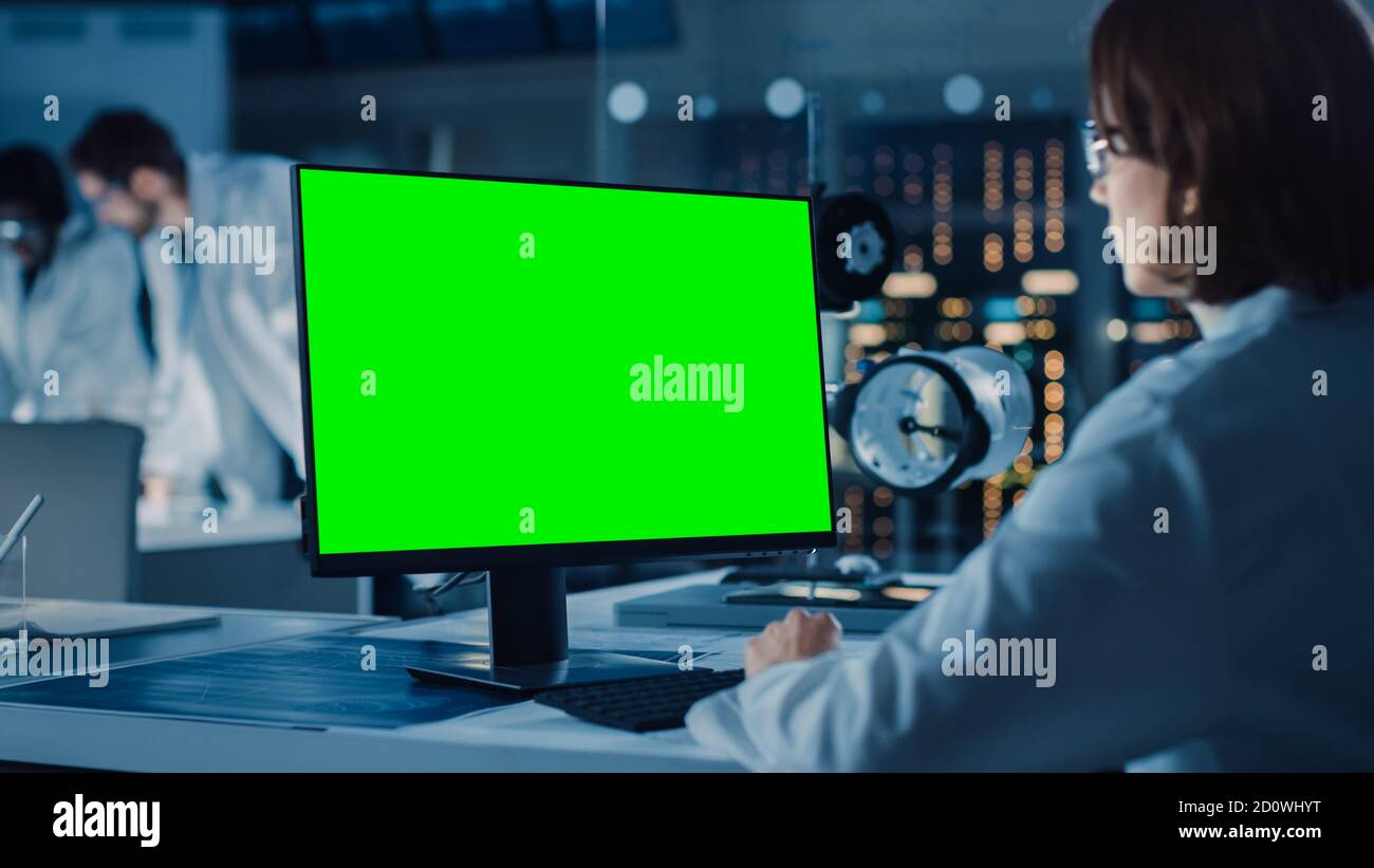 Over the Shoulder Shot: Female IT Scientist Uses Green Mock-up Screen ...