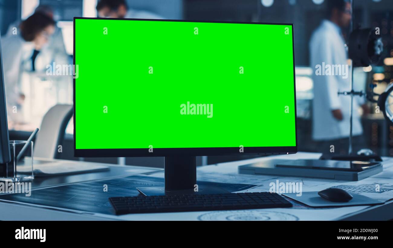 On the Desk Standing Green Mock-up Screen Computer. In the Background ...