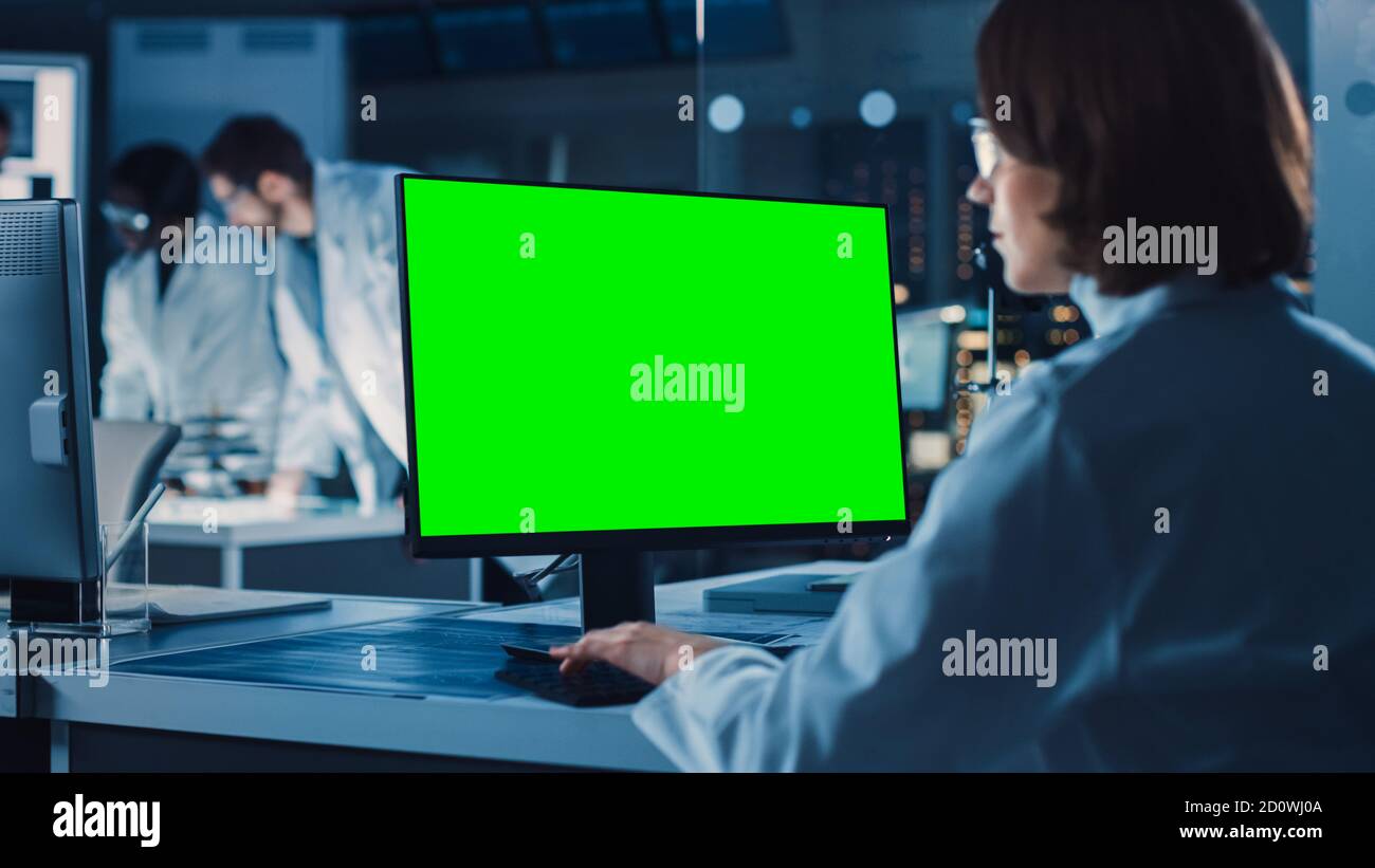 Over the Shoulder Shot: Female IT Scientist Uses Green Mock-up Screen ...