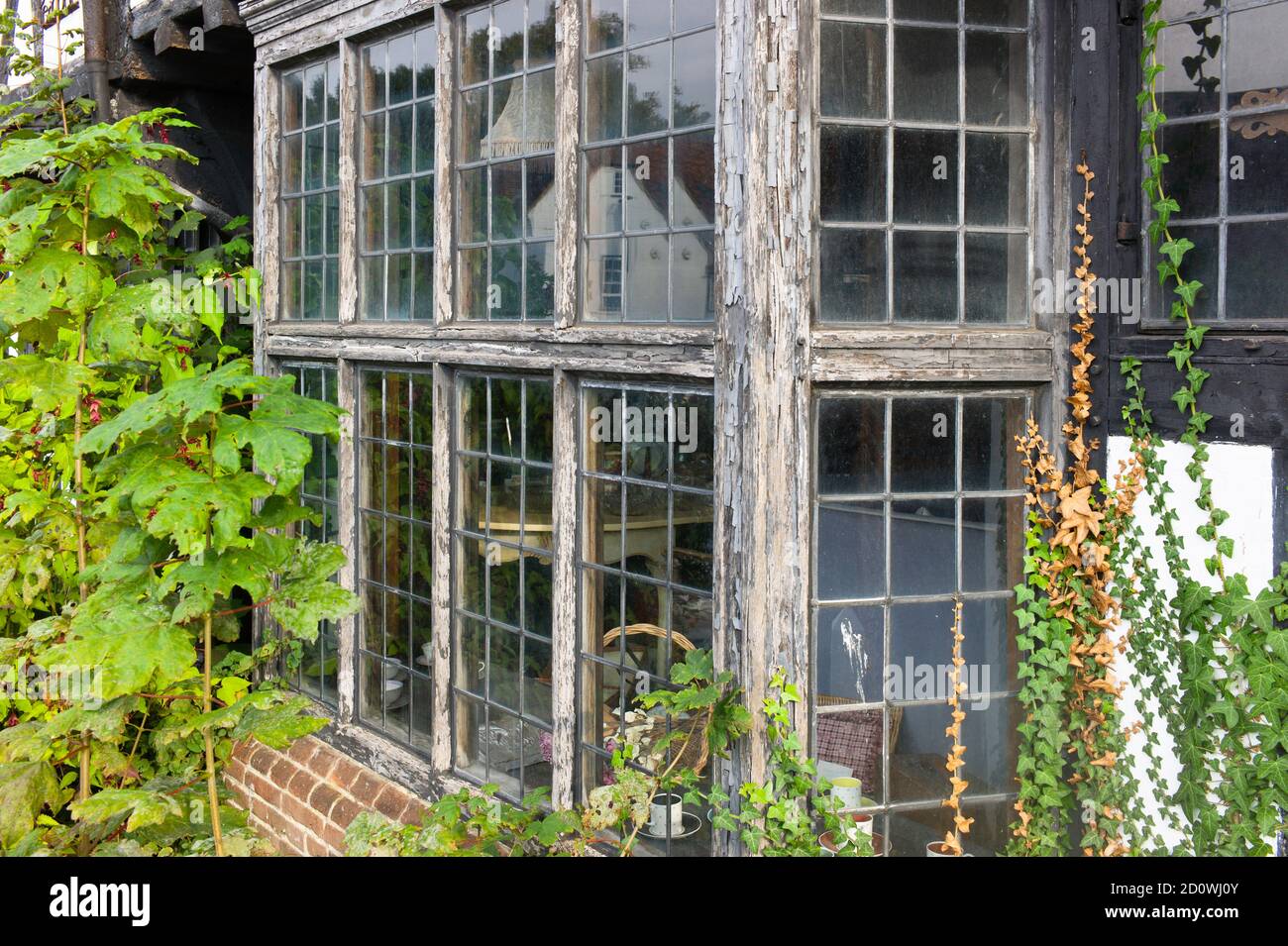 Bay window of paintless weathered worn wood with stained glass windows ...