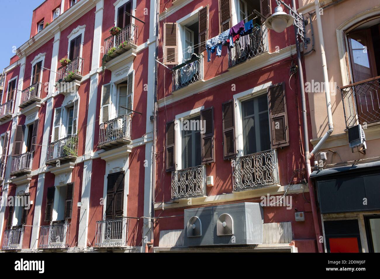 Red plastered facade of a residential building with shuttered windows ...