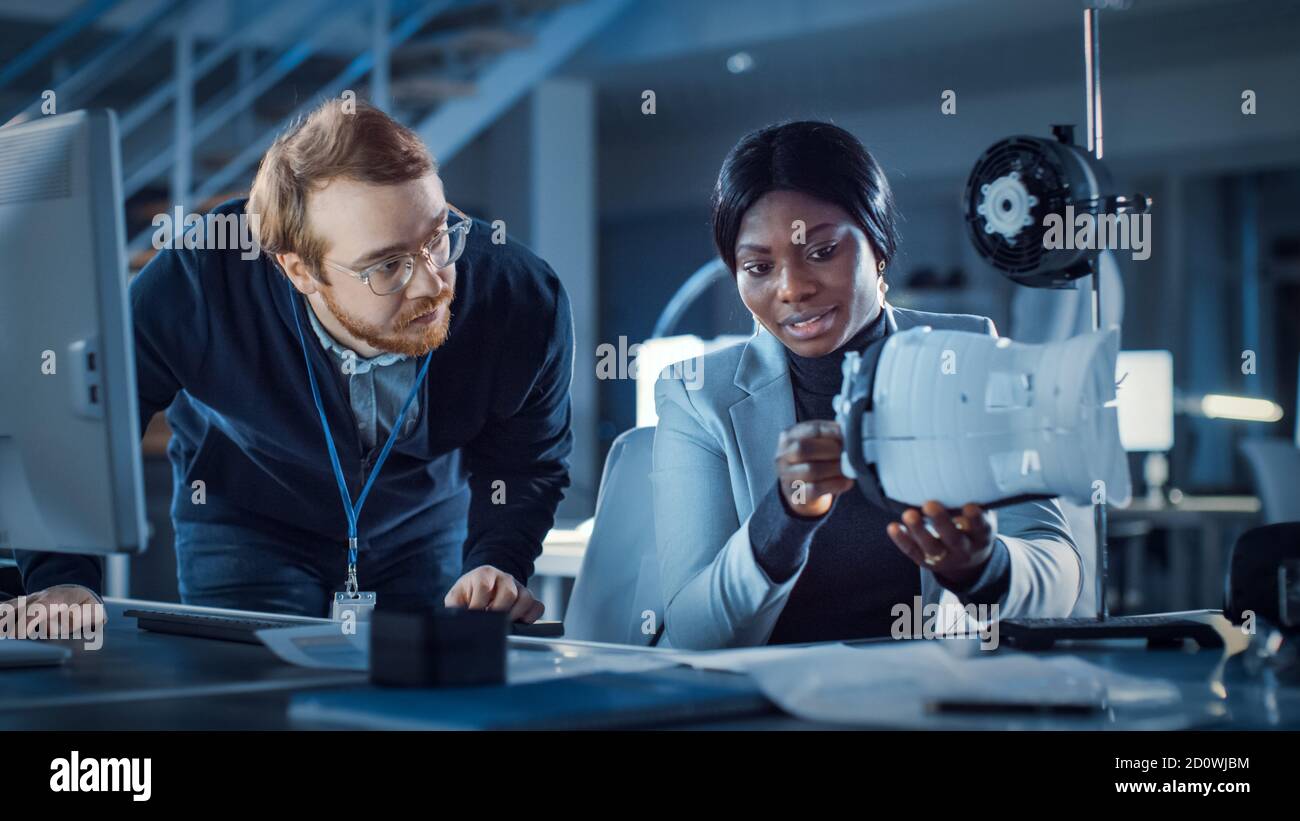 Electronics Development Engineer Working at His Desk, Talks with ...