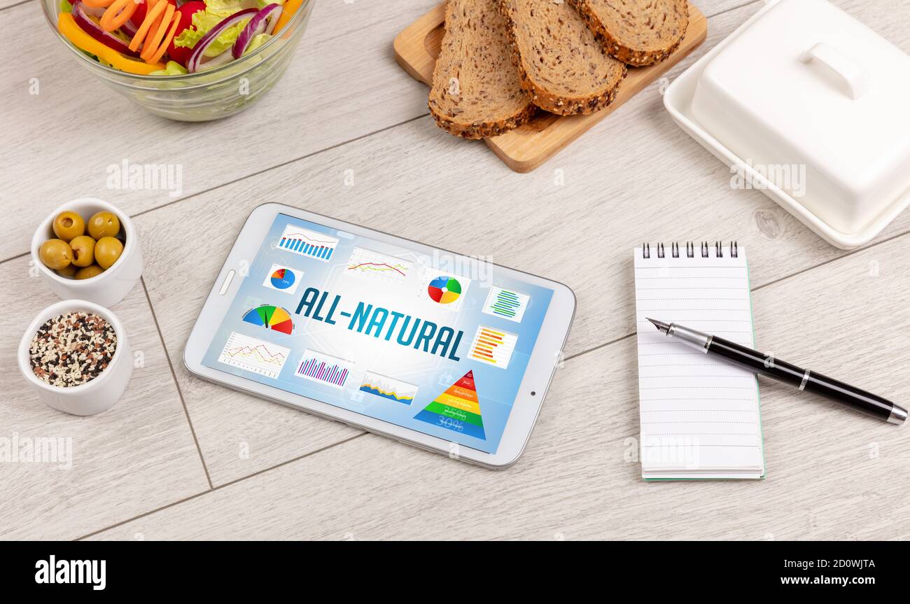 Organic food and tablet pc showing ALL-NATURAL inscription, healthy ...