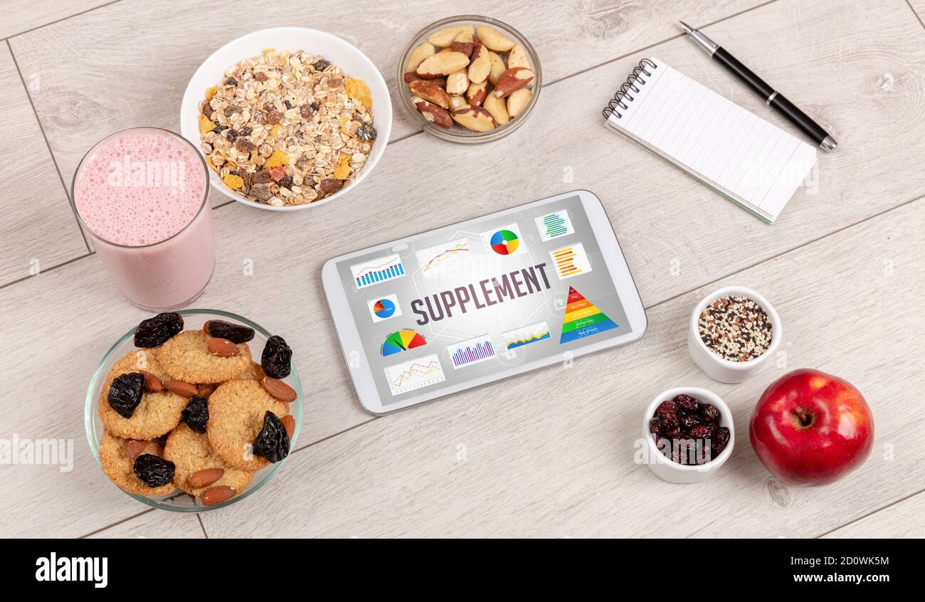 Organic food and tablet pc showing SUPPLEMENT inscription, healthy ...