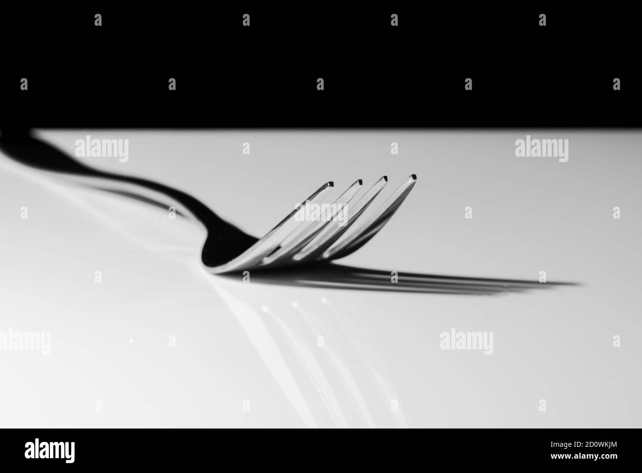 A fork with reflection on light background, closeup with selective ...