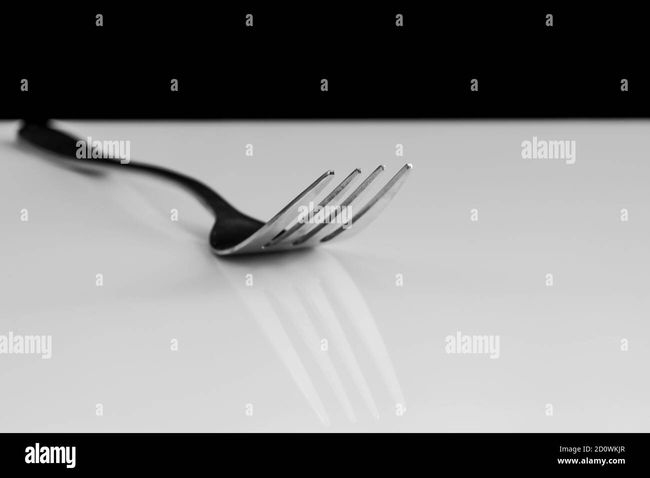 A fork with reflection on light background, closeup with selective ...