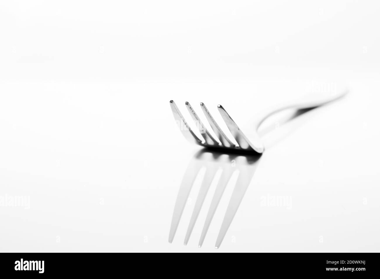 A fork with reflection on light background, closeup with selective ...
