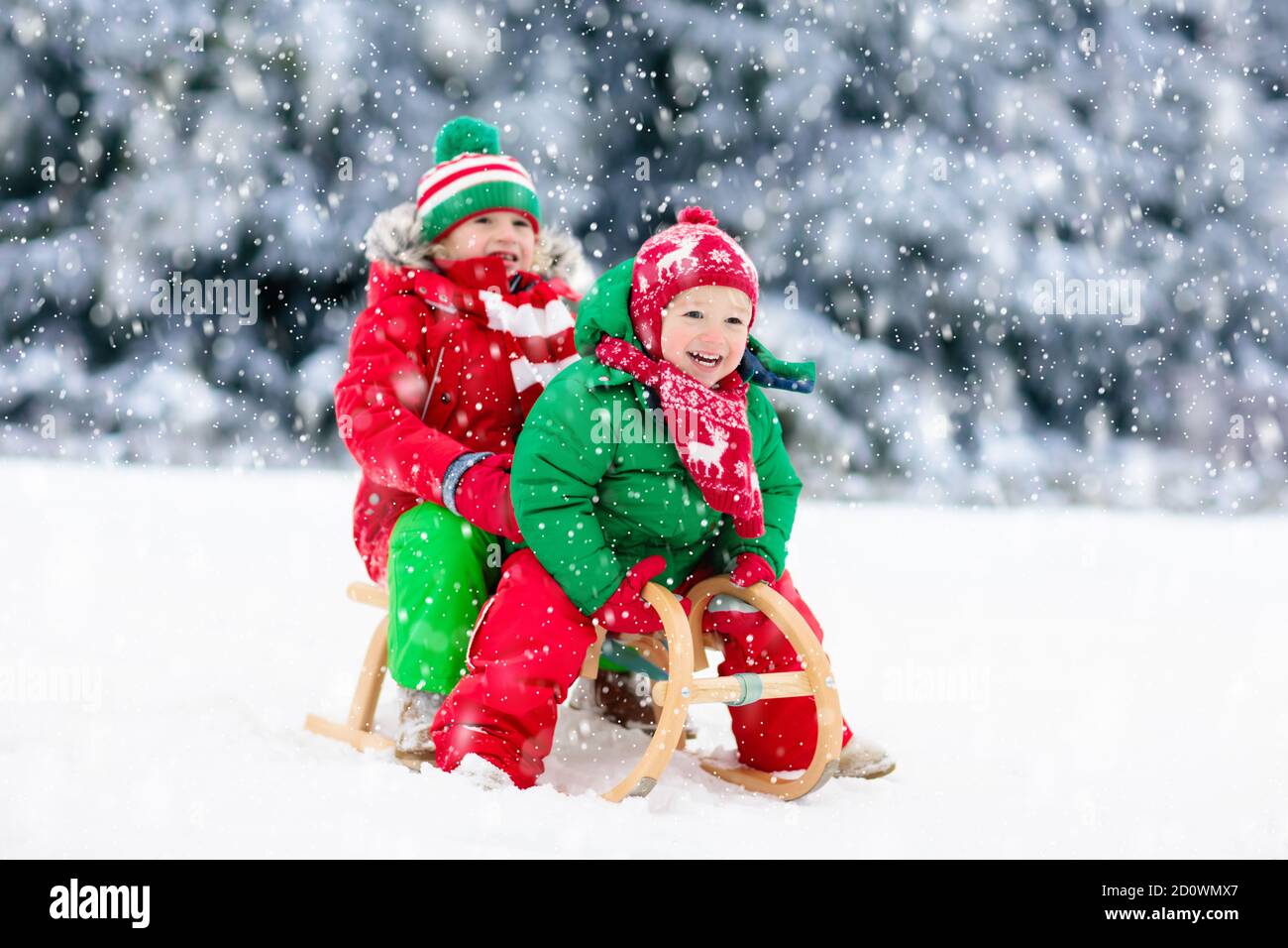 Little girl and boy enjoying sleigh ride. Child sledding. Toddler kid ...