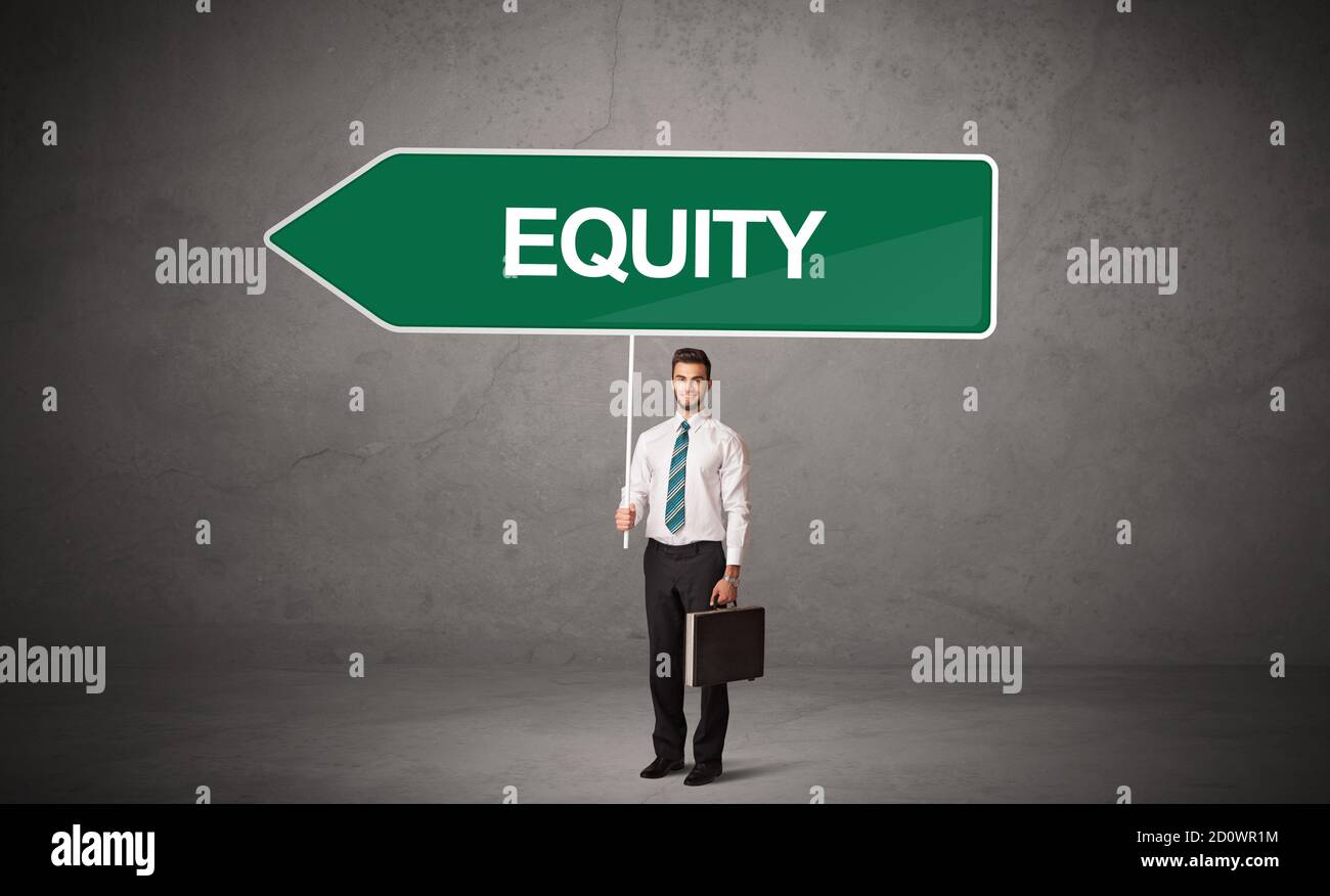 Young business person in casual holding road sign with EQUITY ...