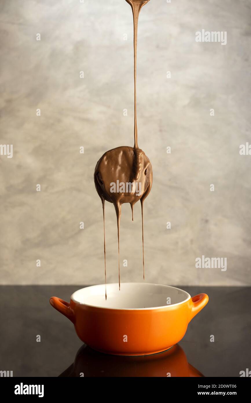 Vertical shot of a piece of cake floating in the air with melted ...