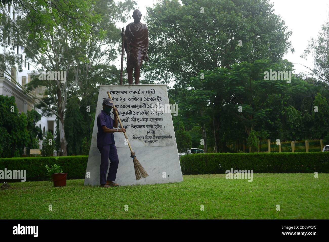 A worker is sweeping near the statue of Mahatma Gandhi on the eve of ...