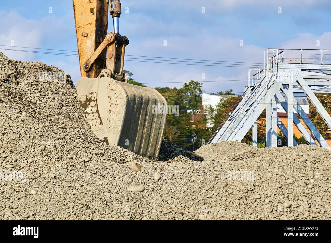 dredging - excavator bucket on a pile of excavated soil in front of a ...