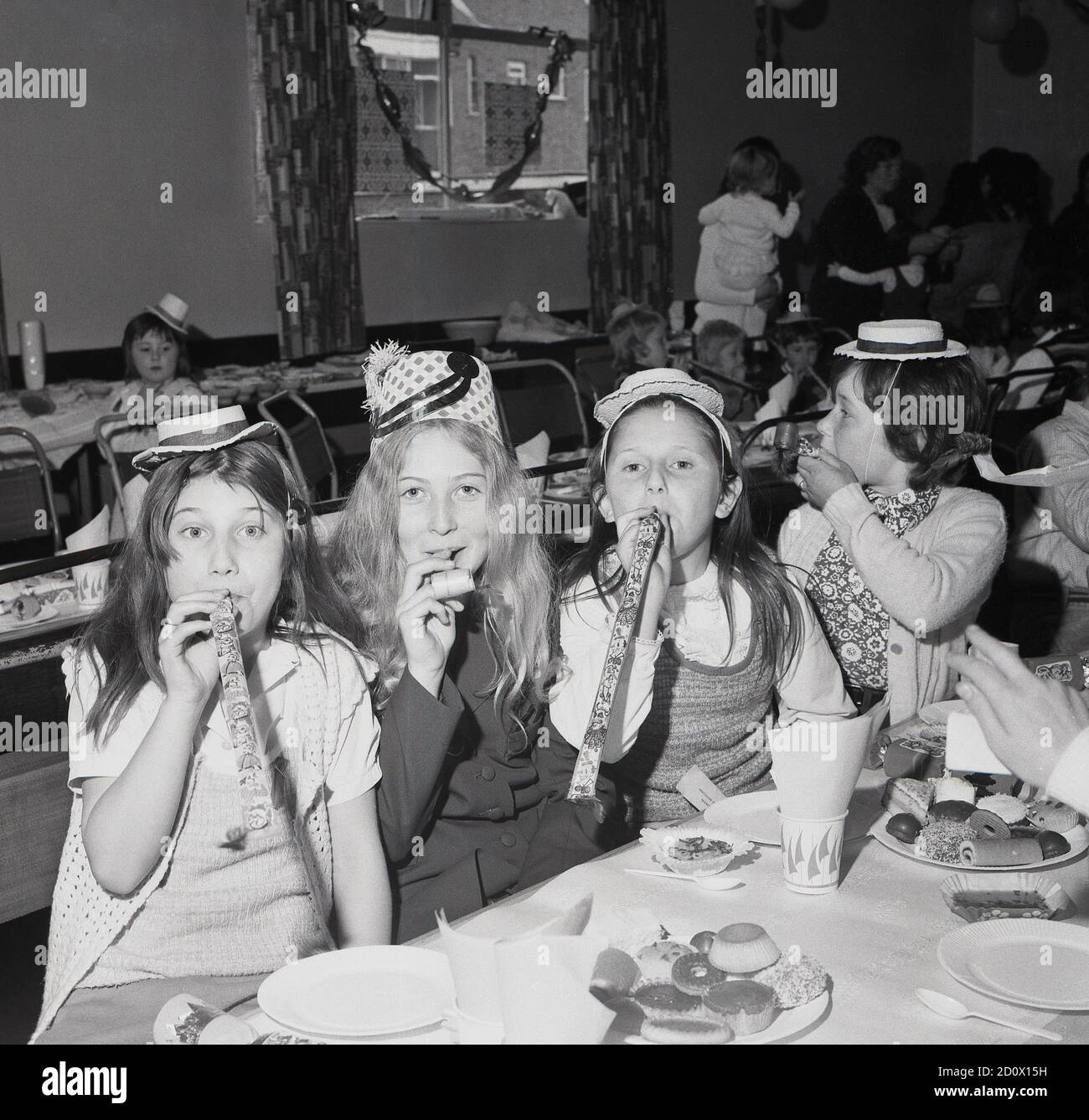 1970s, historical, three young girls having fun at a childrens xmas ...