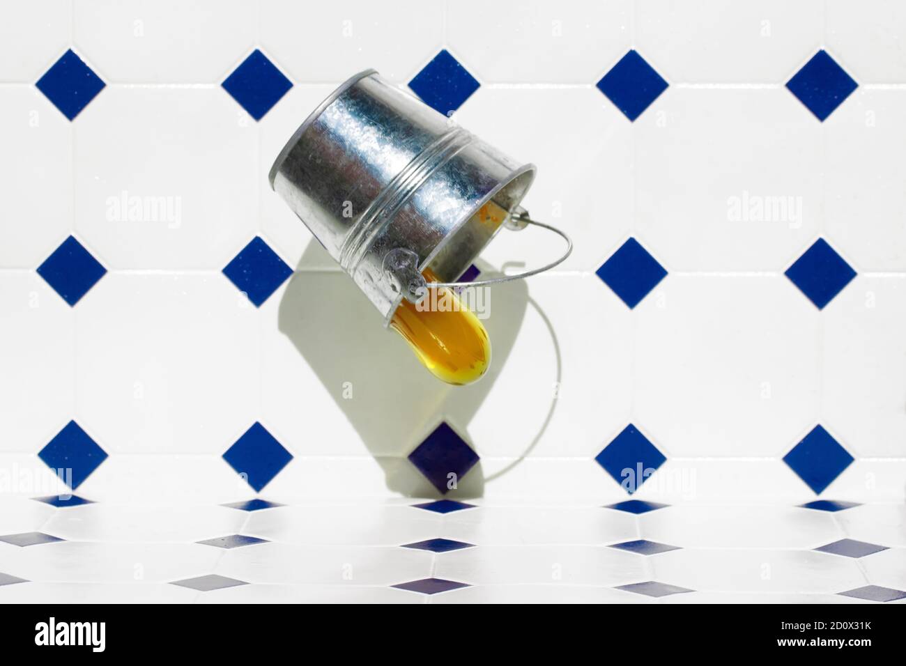 A tin bucket falling to the floor and a liquid flows from it Stock ...