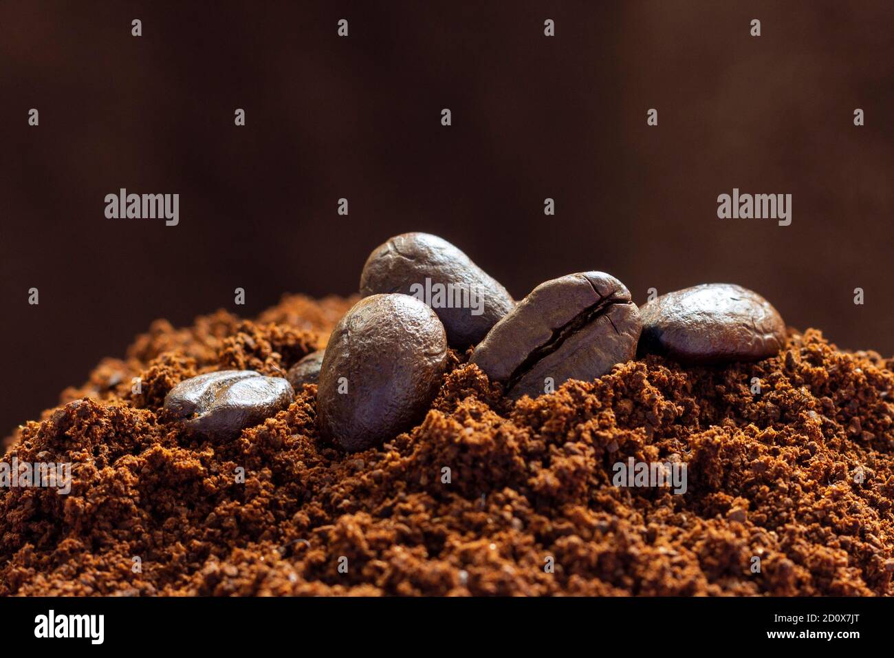 Roasted grains of arabica coffee on the surface of ground coffee Stock ...