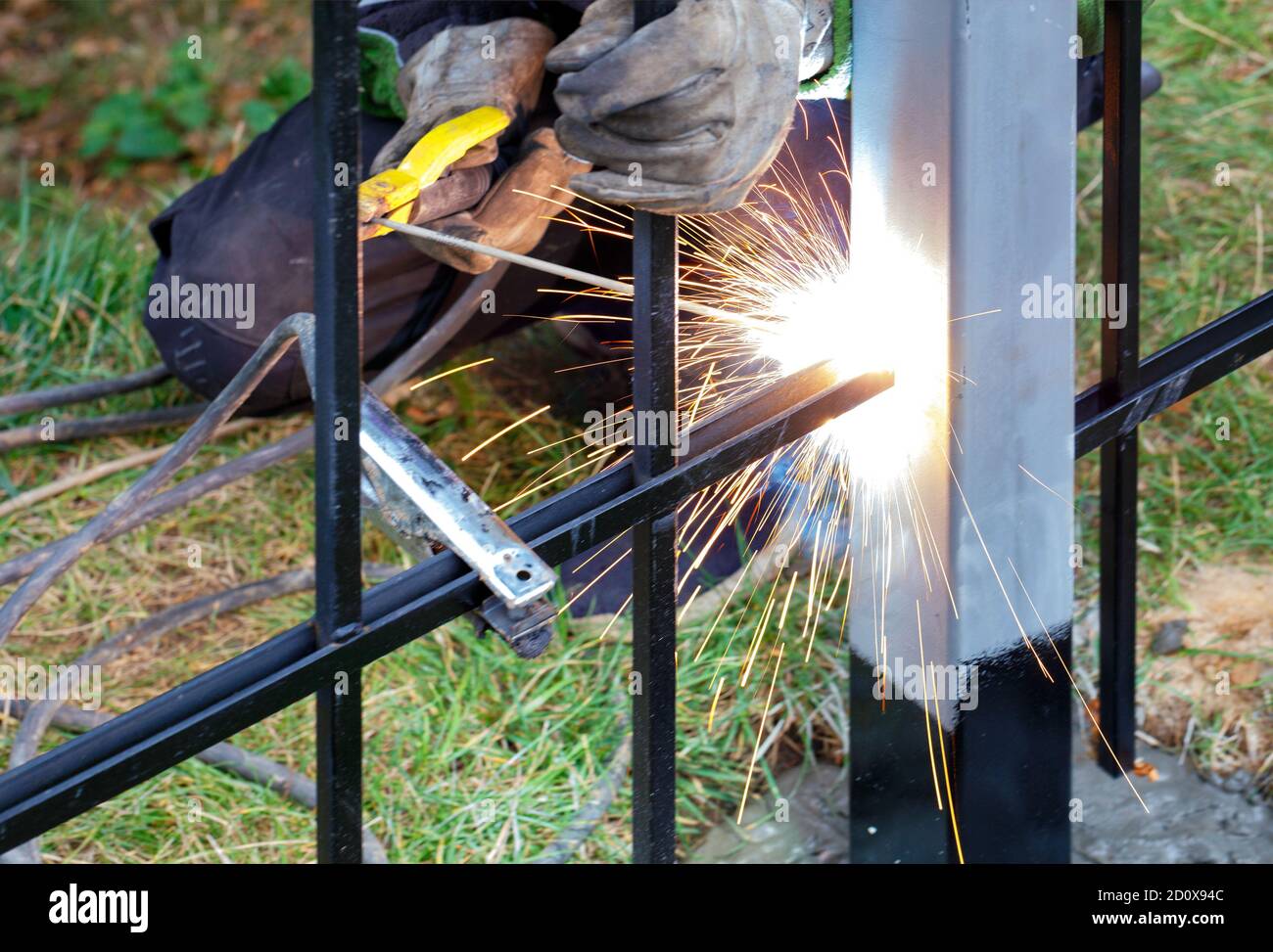 Bright sparks from electric welding fly in different directions against ...