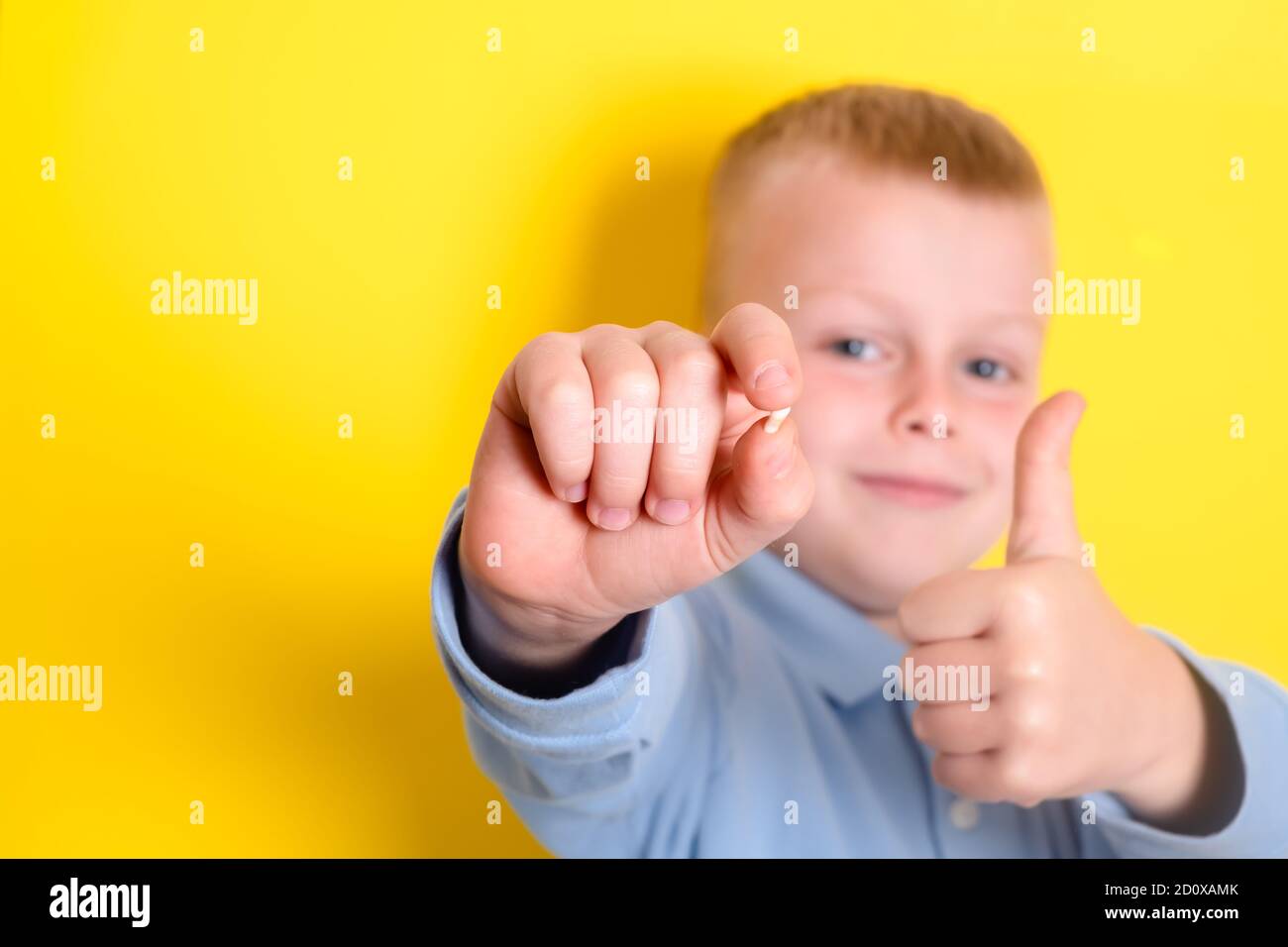 baby tooth in a child's hand. dentistry and health concept. On a yellow ...