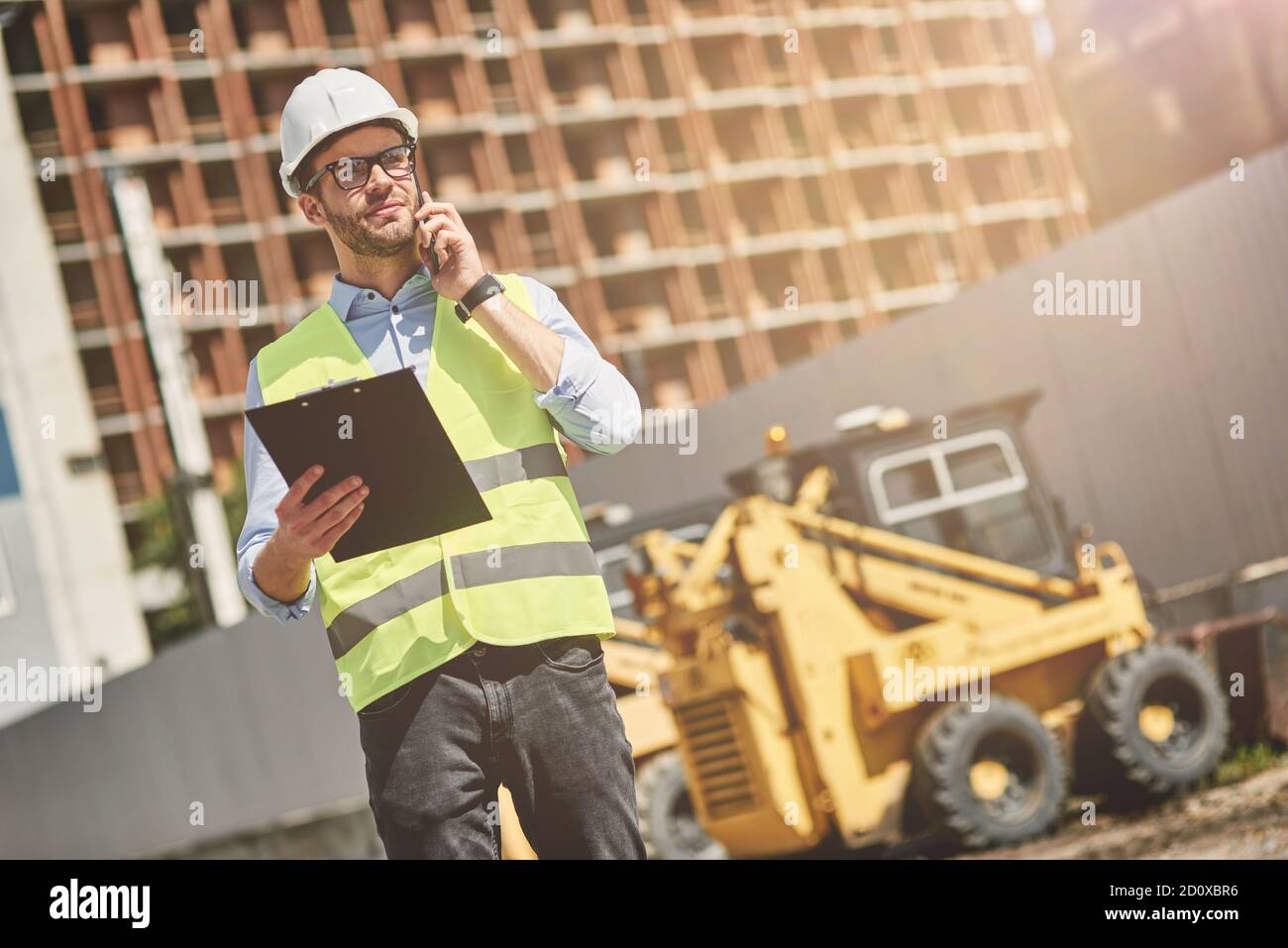 Important call. Young civil engineer or construction supervisor wearing ...