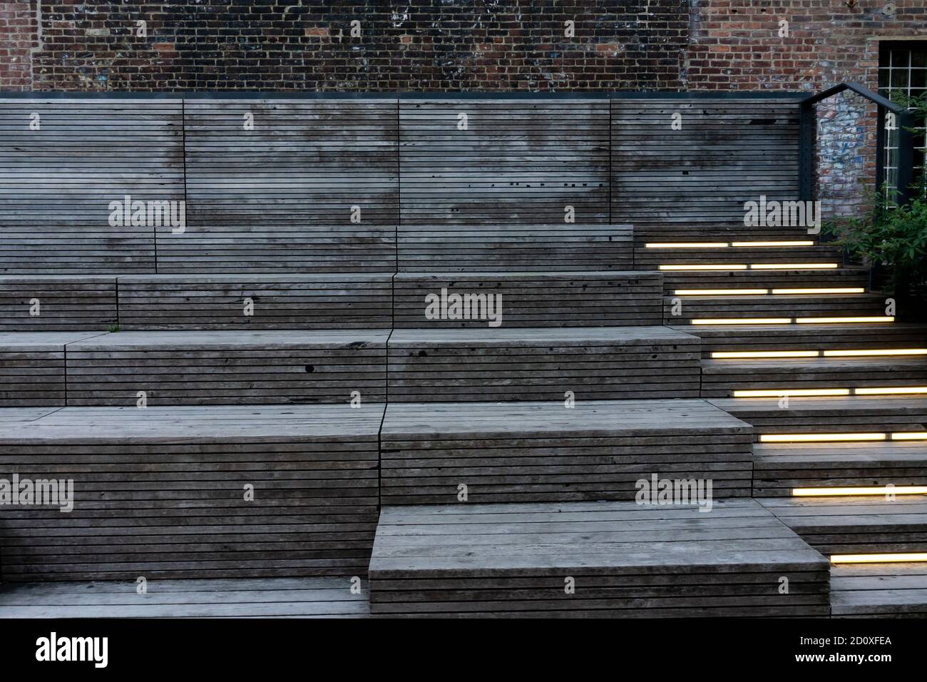 big wooden steps as a sitting area in the High Line. Neon on the steps ...