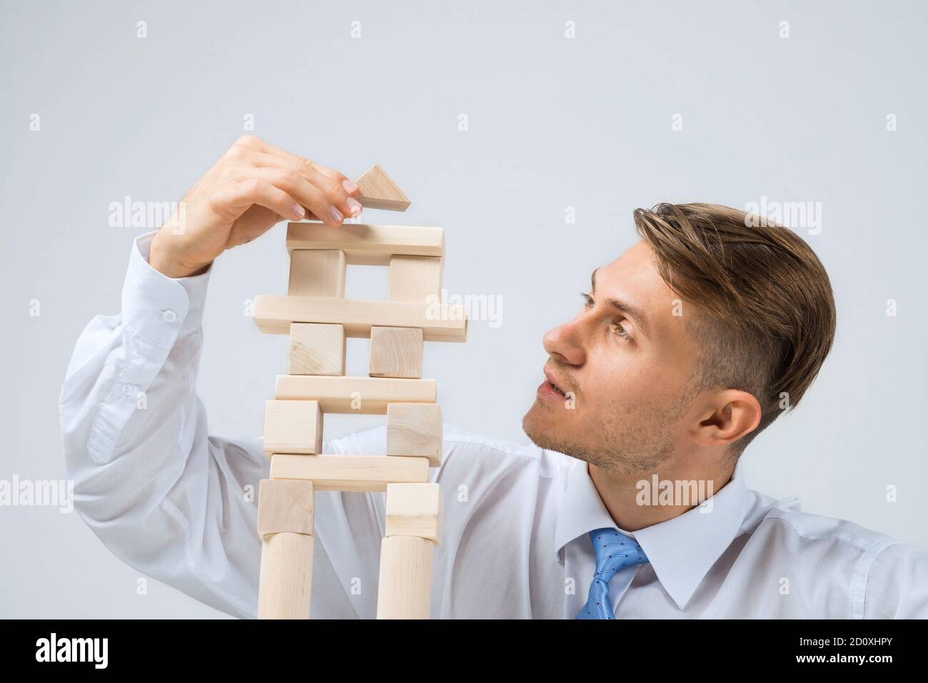 Businessman making tower Stock Photo - Alamy