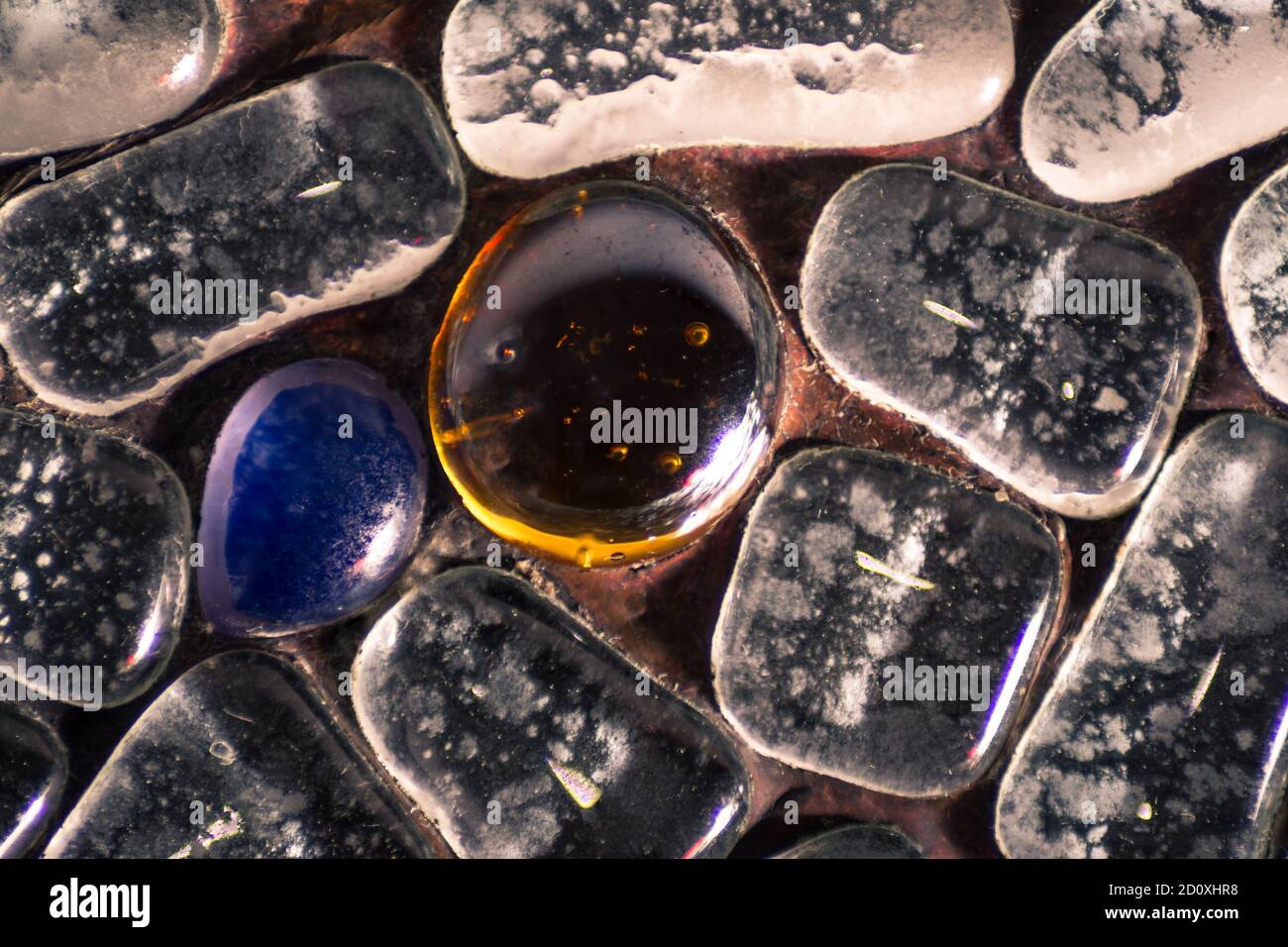 Beautiful light reflection on a orange glass stone and other stones ...