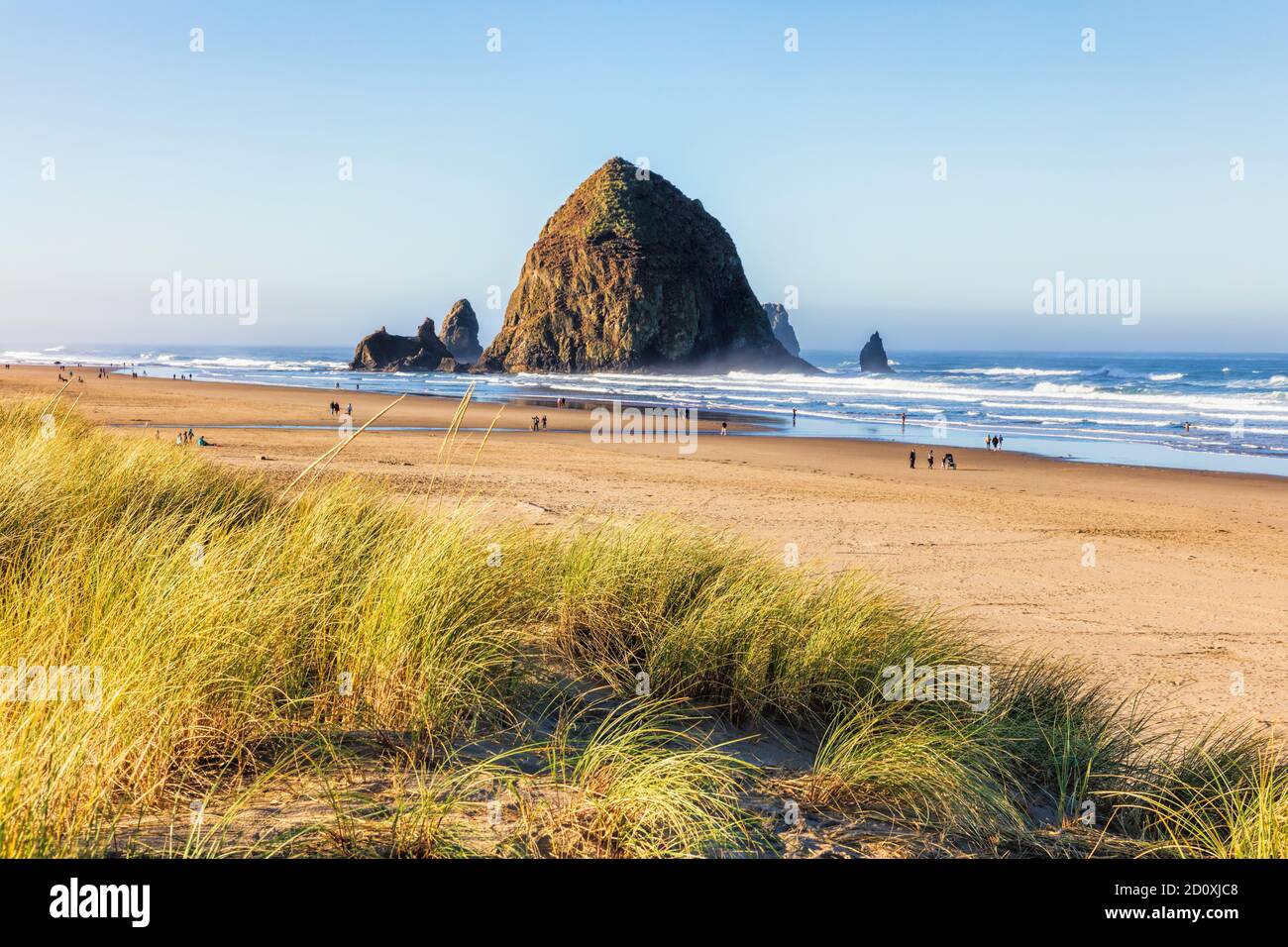 People walking on the beach near Haystack Rock on the Oregon coast ...