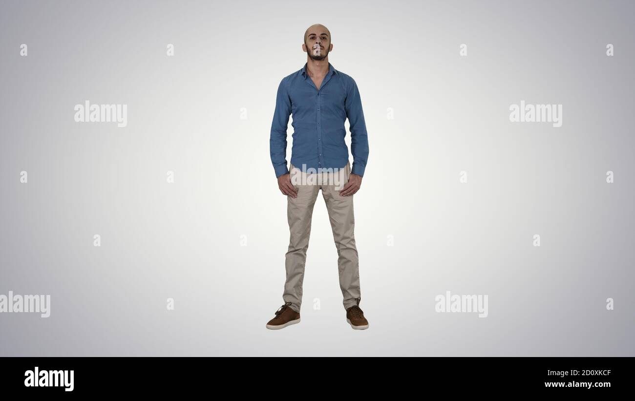 Strict man standing and looking into camera on gradient background ...