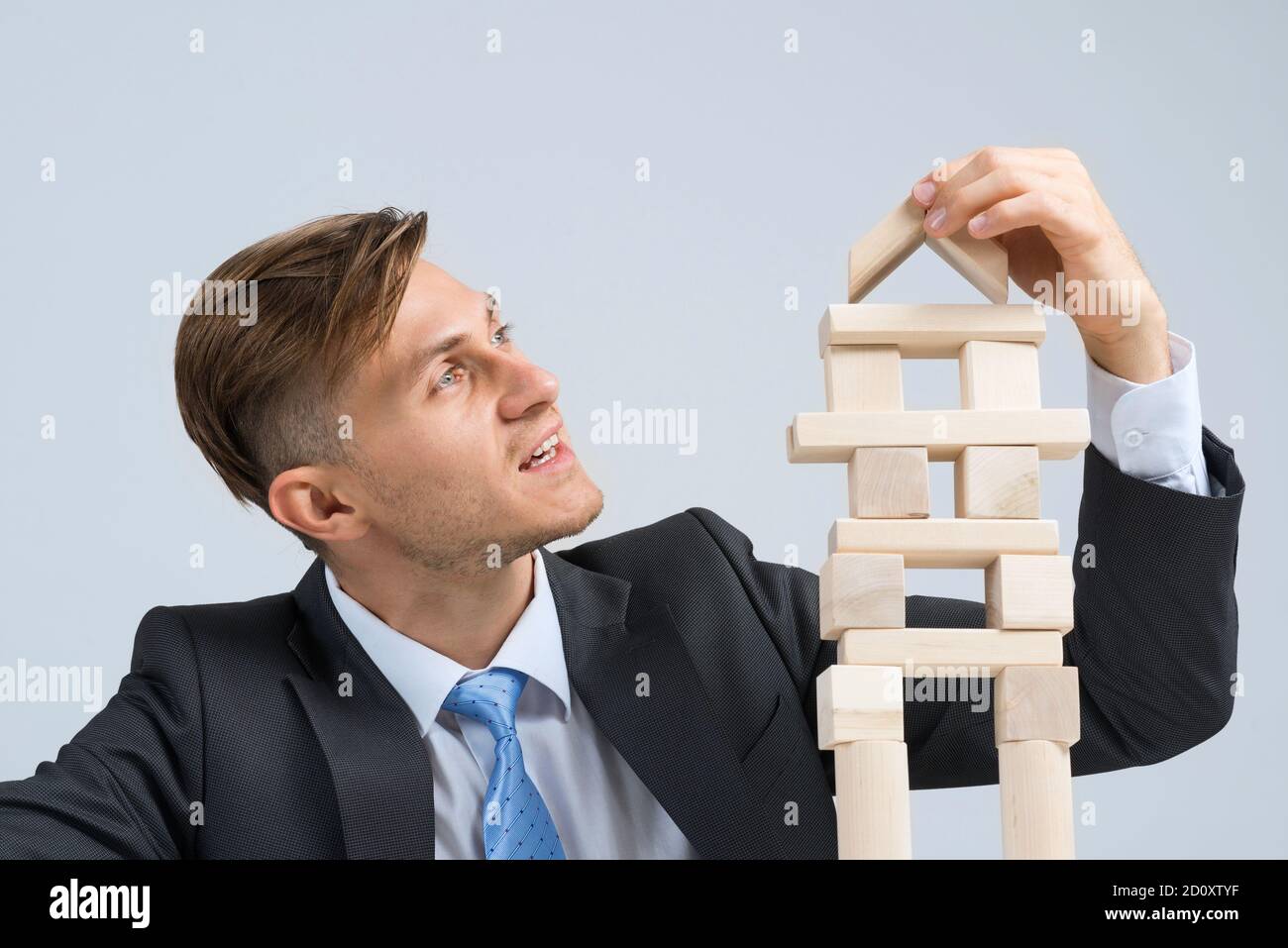 Businessman making tower Stock Photo - Alamy