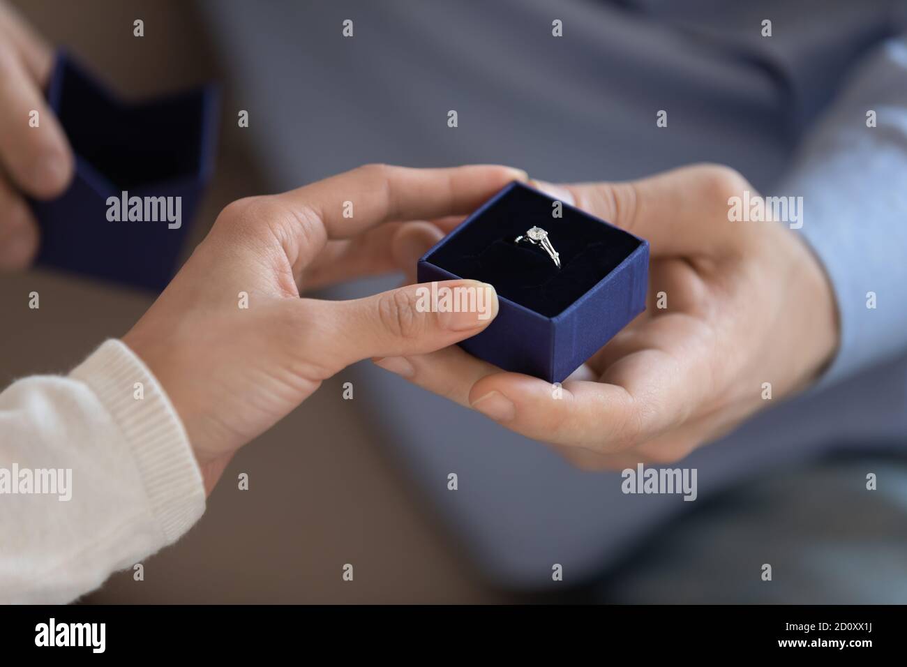 Young male presenting engagement ring to beloved female Stock Photo - Alamy