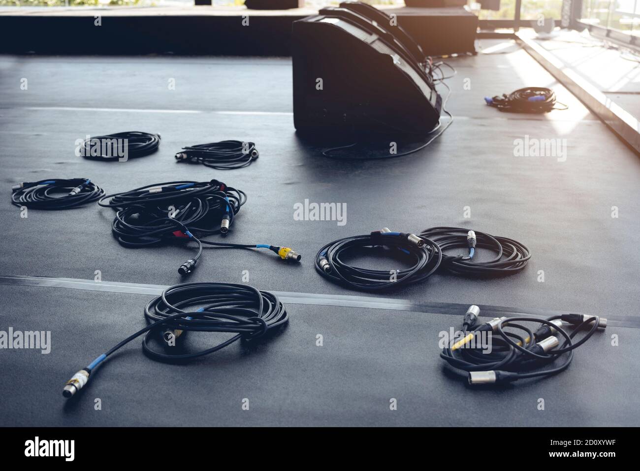 In preparation for a concert, audio cables and speakers are on the ...