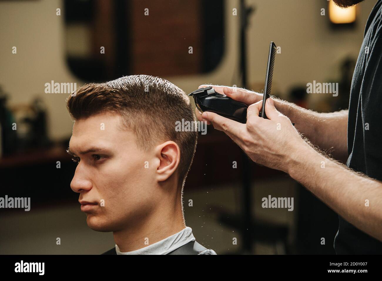 Confident young man in a barber shop getting a trim Stock Photo - Alamy