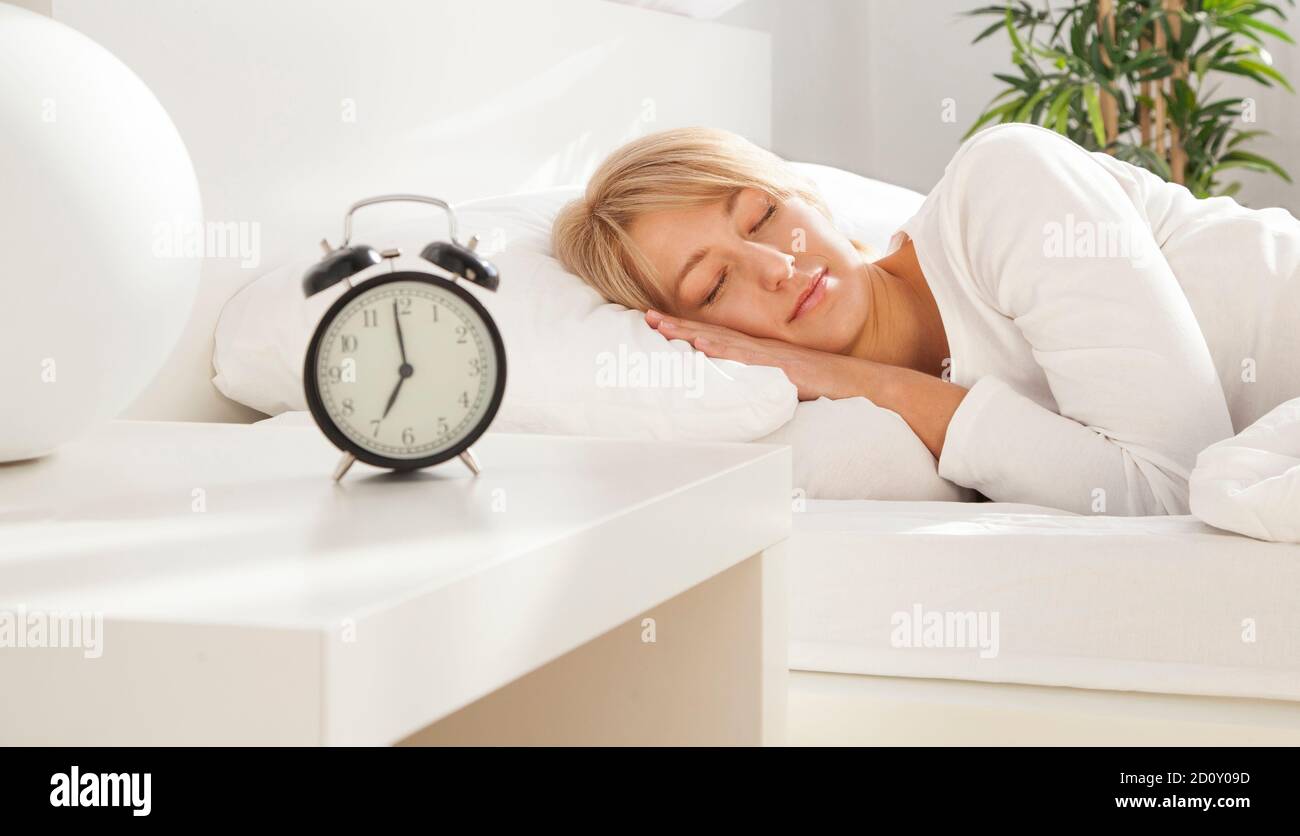 Beautiful Girl Sleeping In Her Bed Clock On The Nightstand Focus On