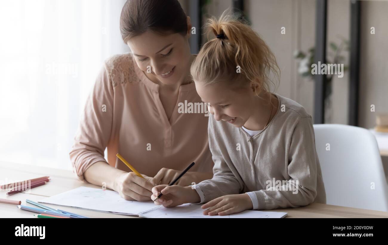 Happy young woman with little daughter drawing colored pencils Stock ...
