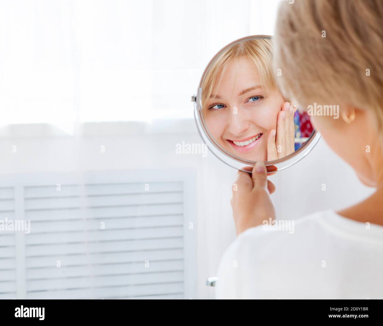 Beautiful Young Woman In The Morning Looks In The Mirror Touches The