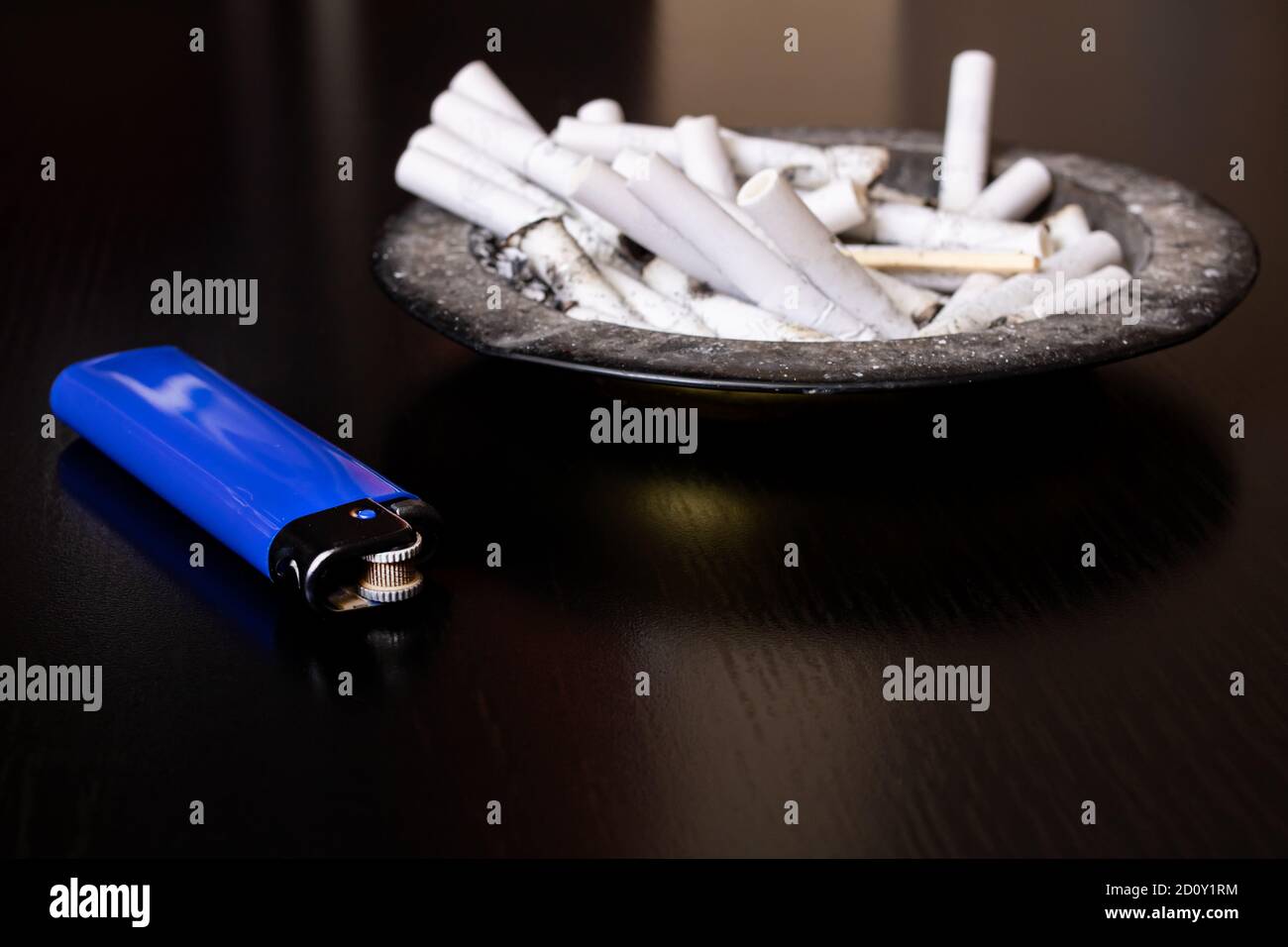 Lighter and ashtray on a wooden table Stock Photo - Alamy