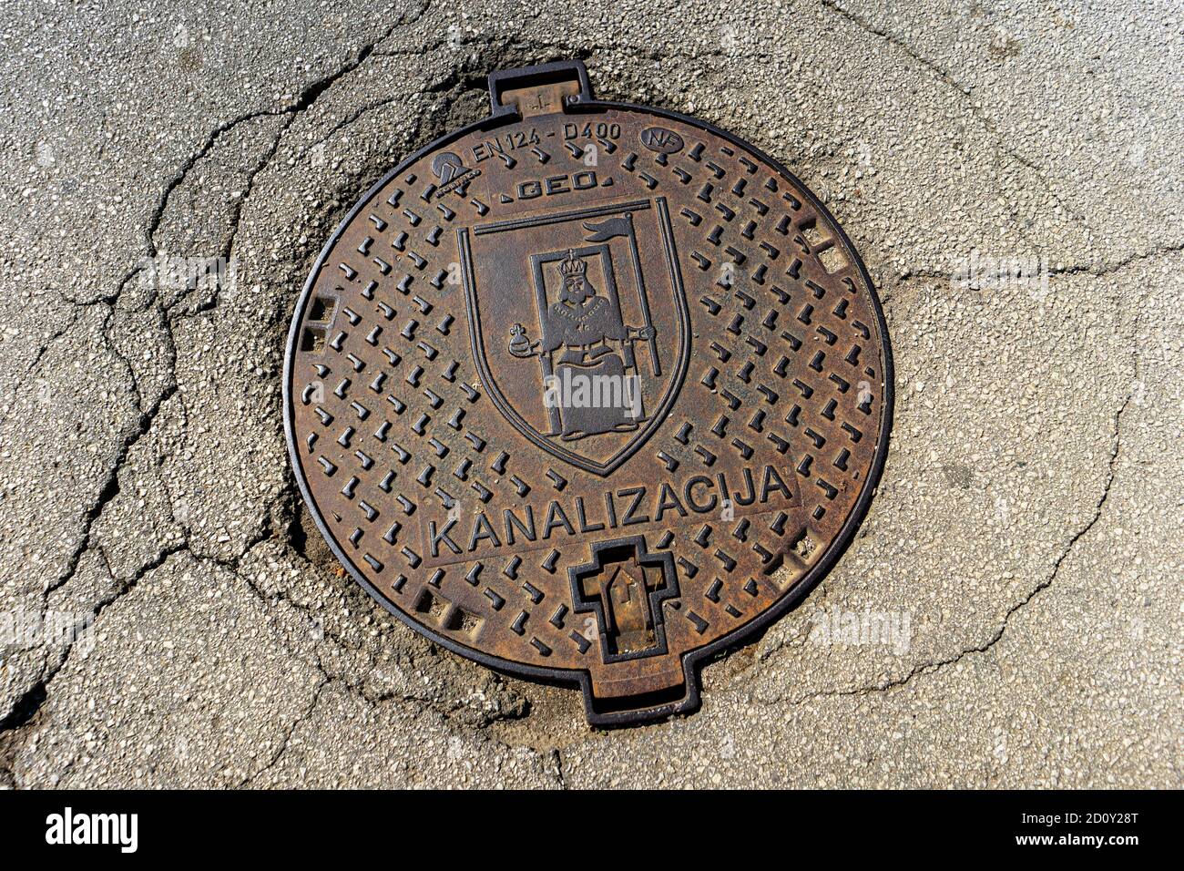 Manhole, sewer cover on the old street Stock Photo - Alamy