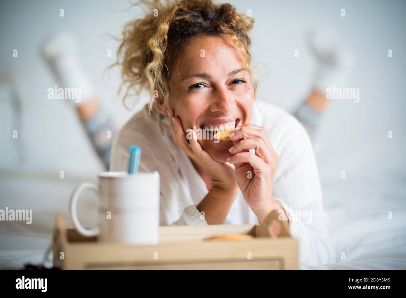 Portrait of adult beautiful woman eating cookie in morning breakfast in ...