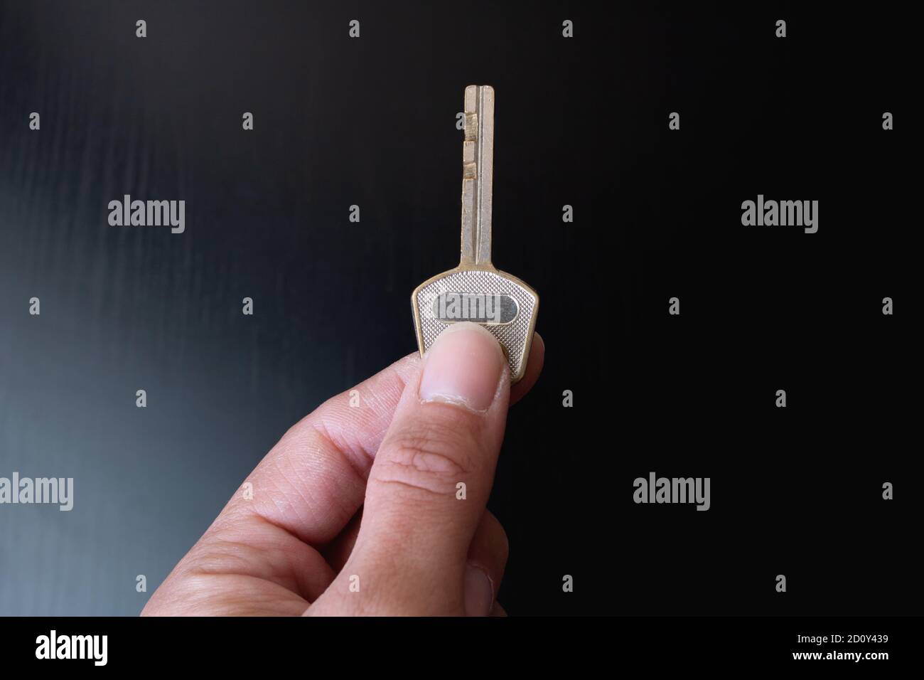 Key in hand on a black background Stock Photo - Alamy