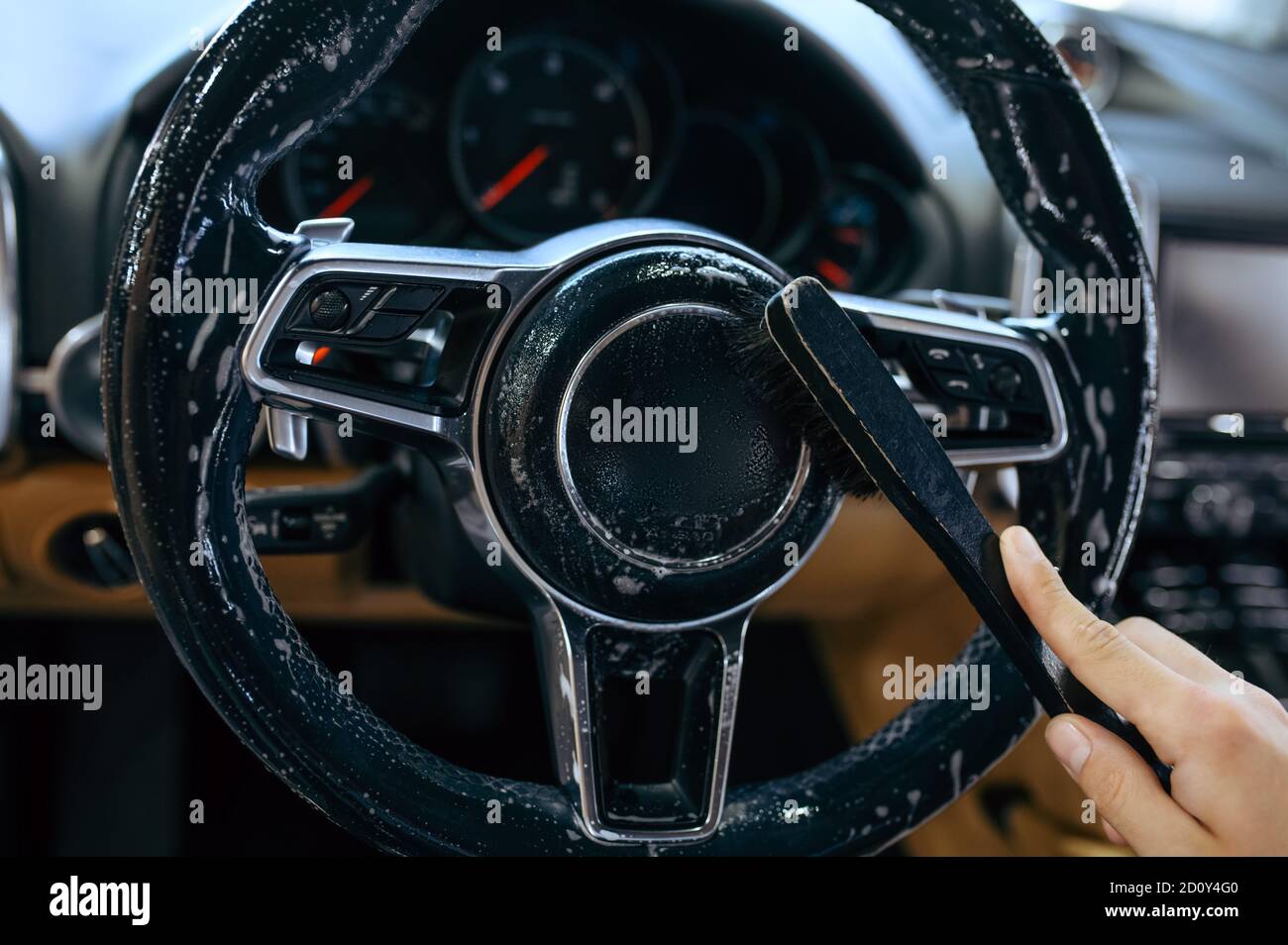 Worker wipes car steering wheel, detailing Stock Photo - Alamy