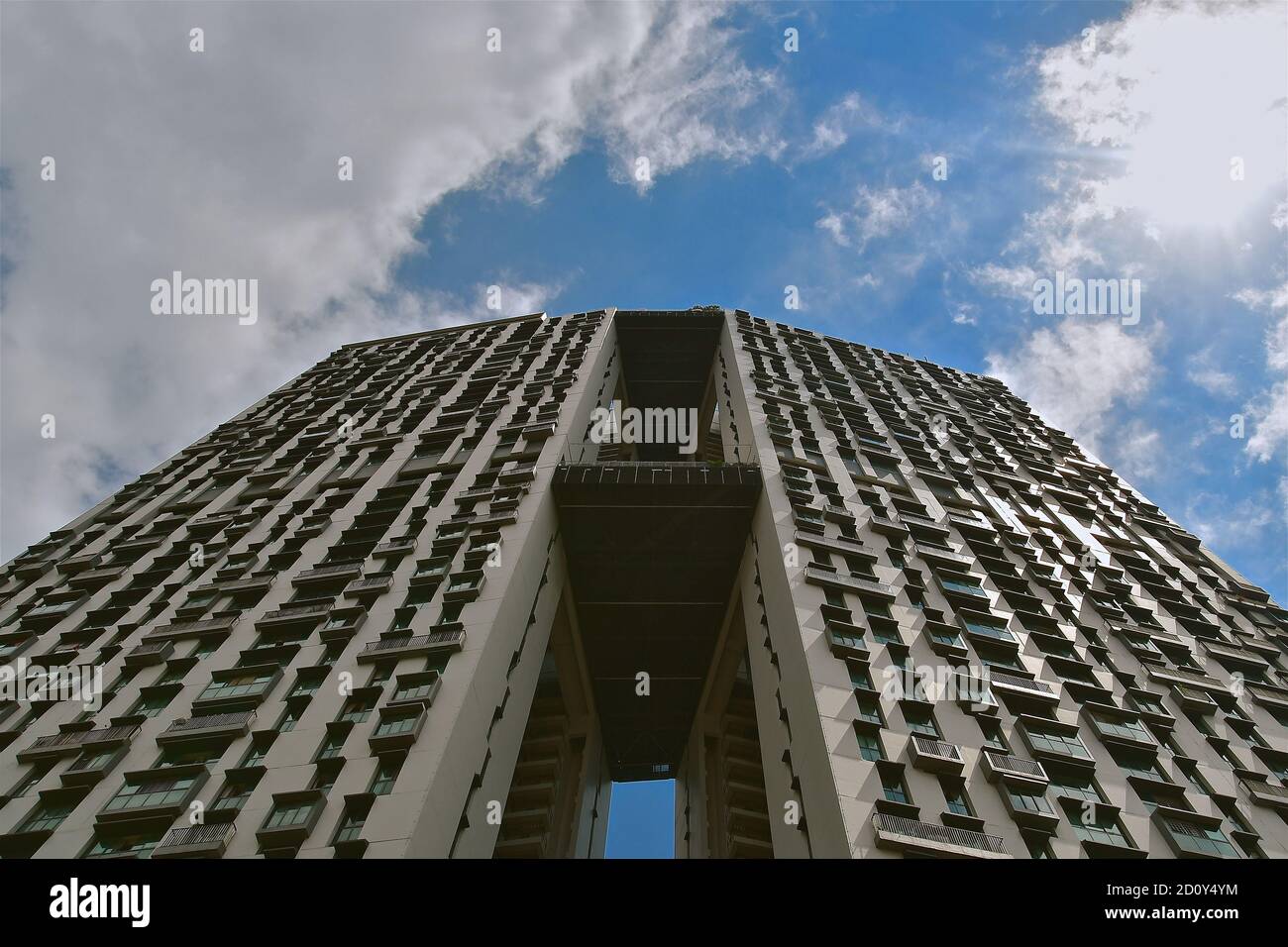 Upward perspective view modern apartments against a cloudy blue sky ...