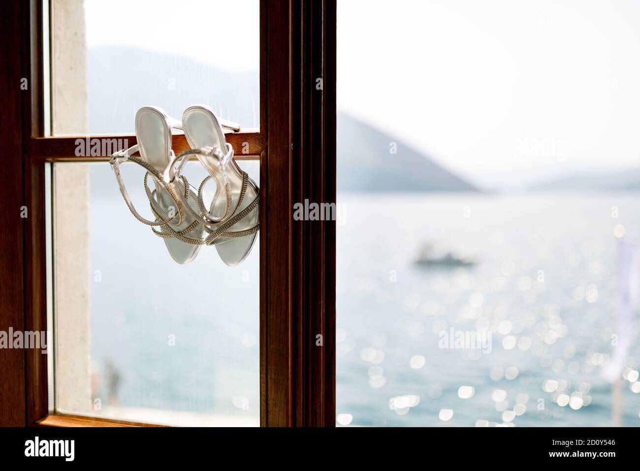 Bridal sandals on a wooden window frame overlooking the sea Stock Photo ...